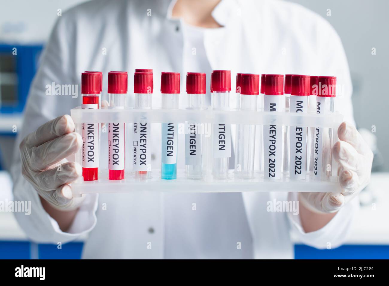 Cropped view of scientist in latex gloves holding test tubes with ...