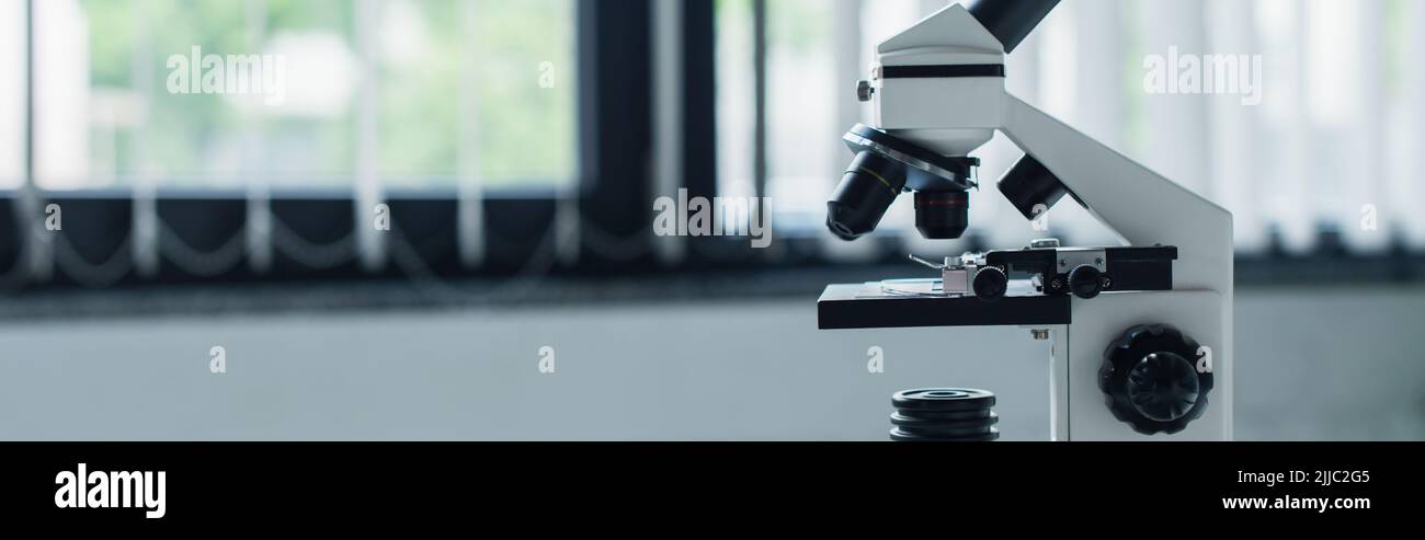 Microscope in blurred laboratory at background, banner Stock Photo - Alamy