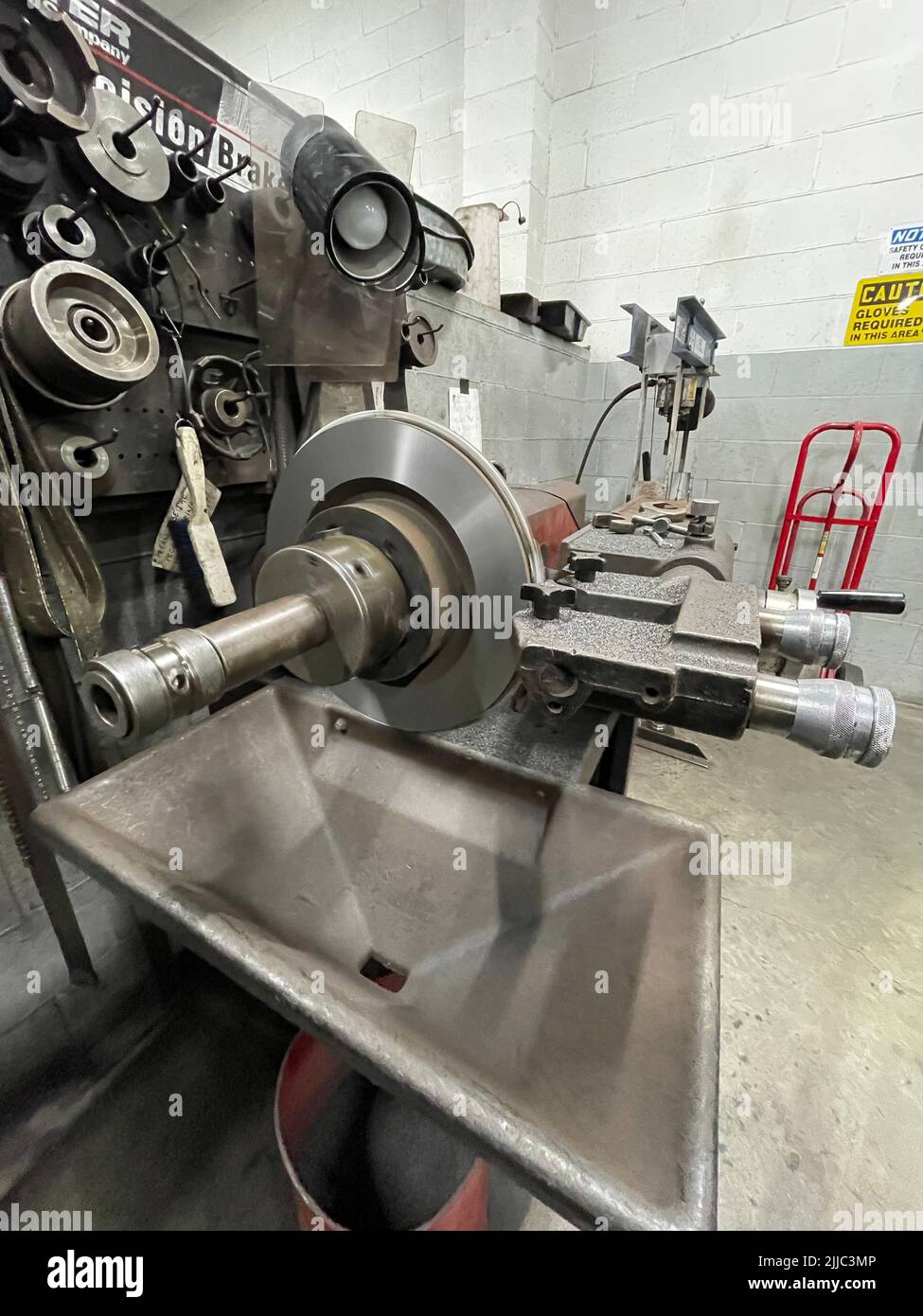 Car brake rotor being machined on a brake lathe at an automotive shop ...