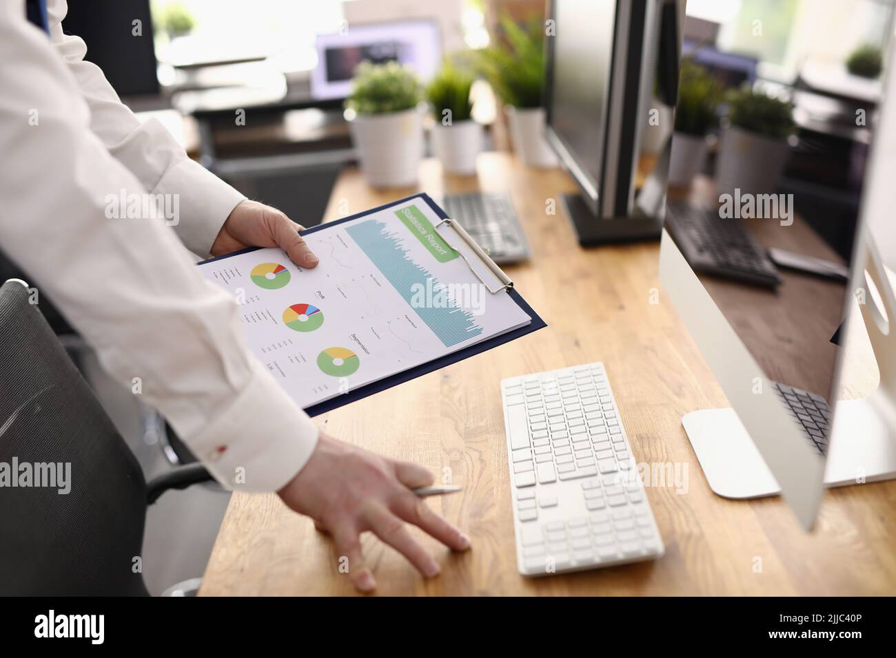 Analyst employee holds clipboard with graphs at workplace Stock Photo ...