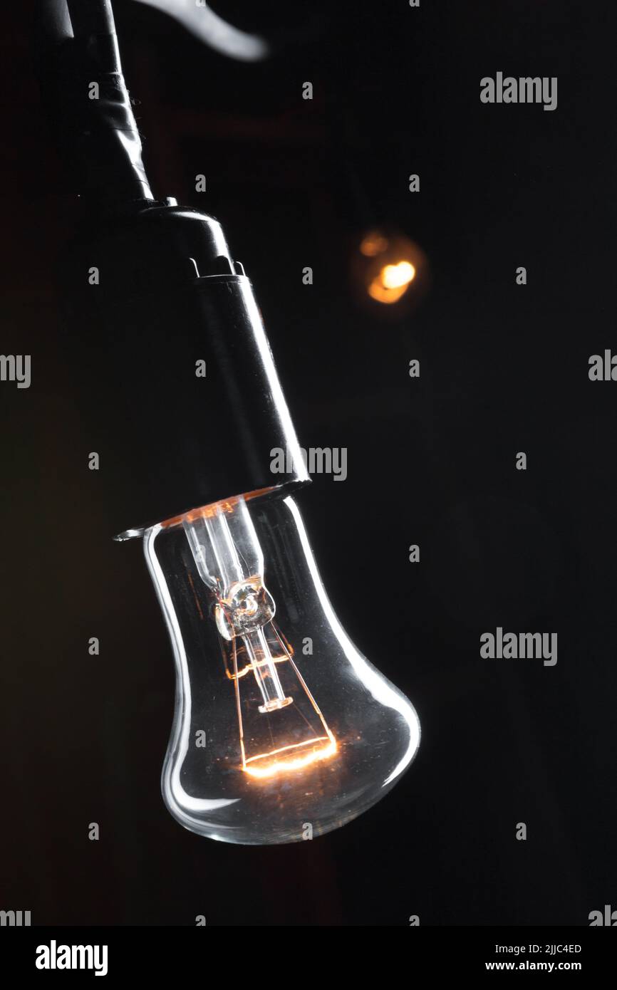 A classic Edison light bulb on dark background with space for text ...