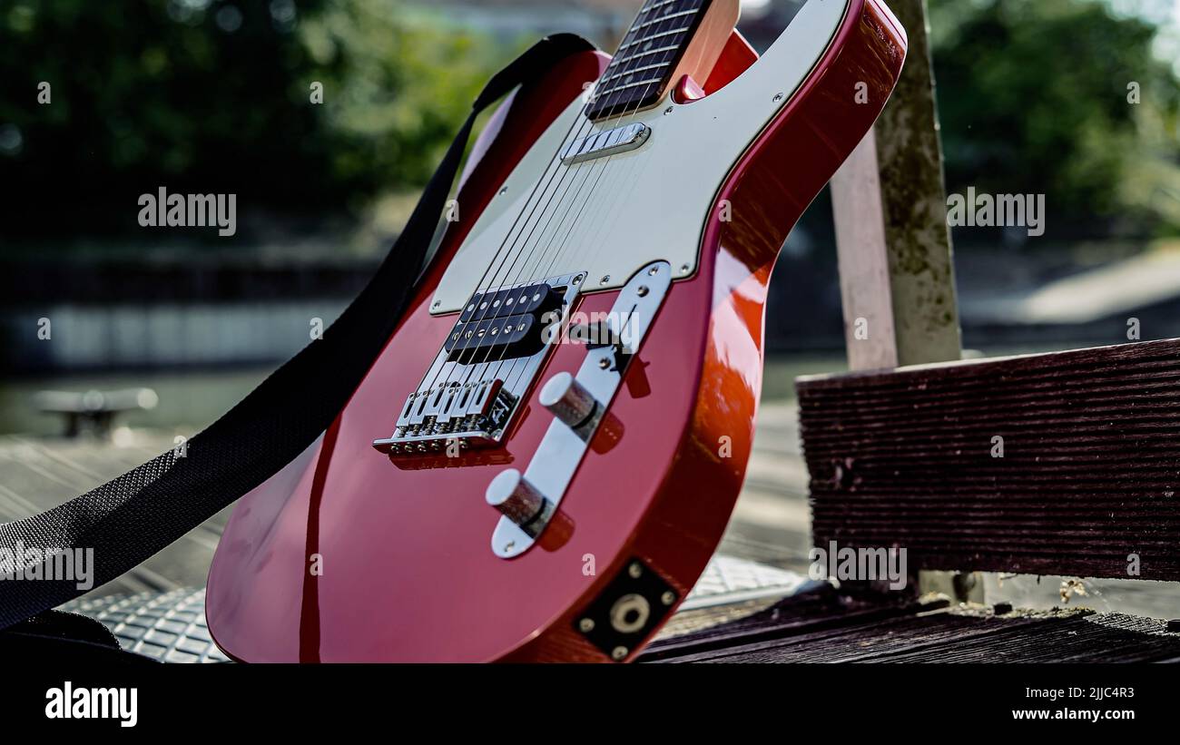 Acoustic guitar rests against wooden post on a pier with a natural ...