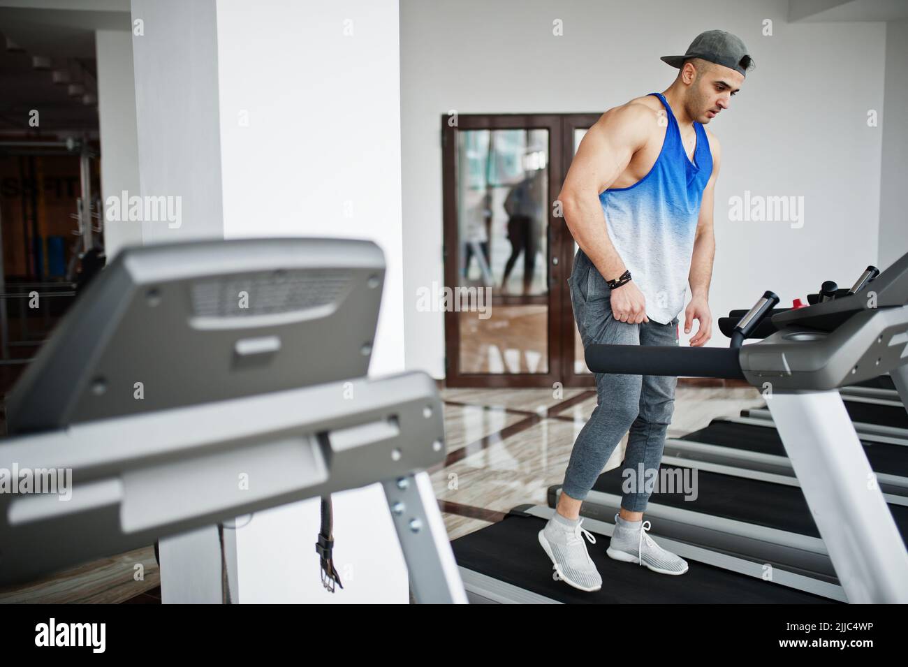 Fit and muscular arabian man running on treadmill in gym Stock Photo ...