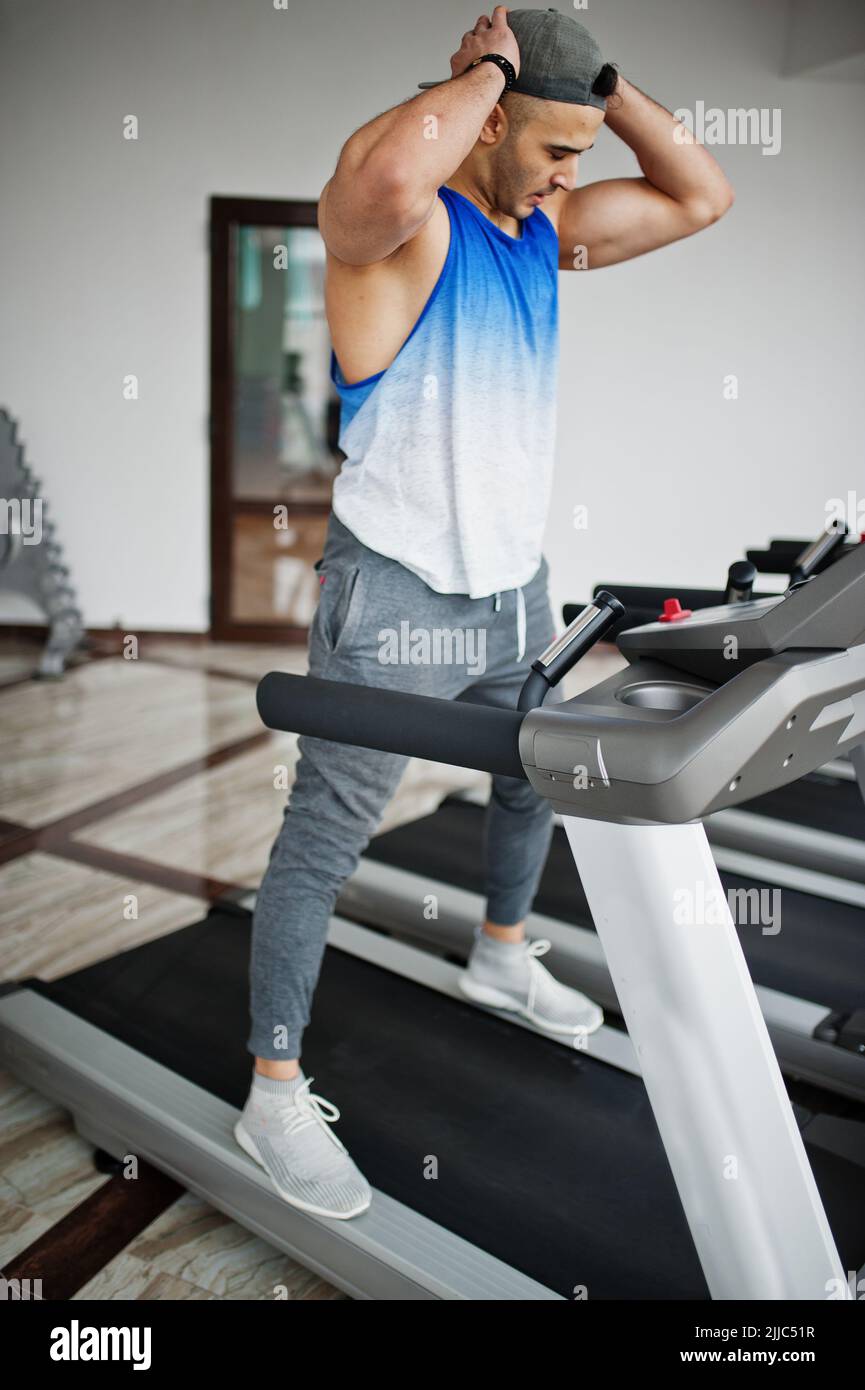 Fit and muscular arabian man running on treadmill in gym Stock Photo ...