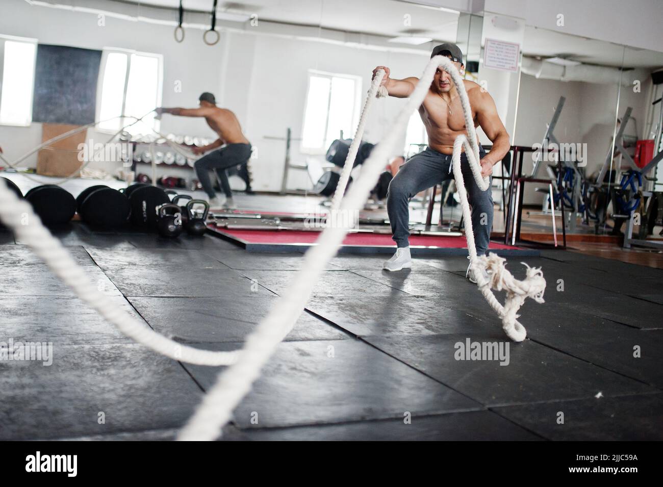 Fit and muscular arabian man working out with heavy ropes in gym Stock ...