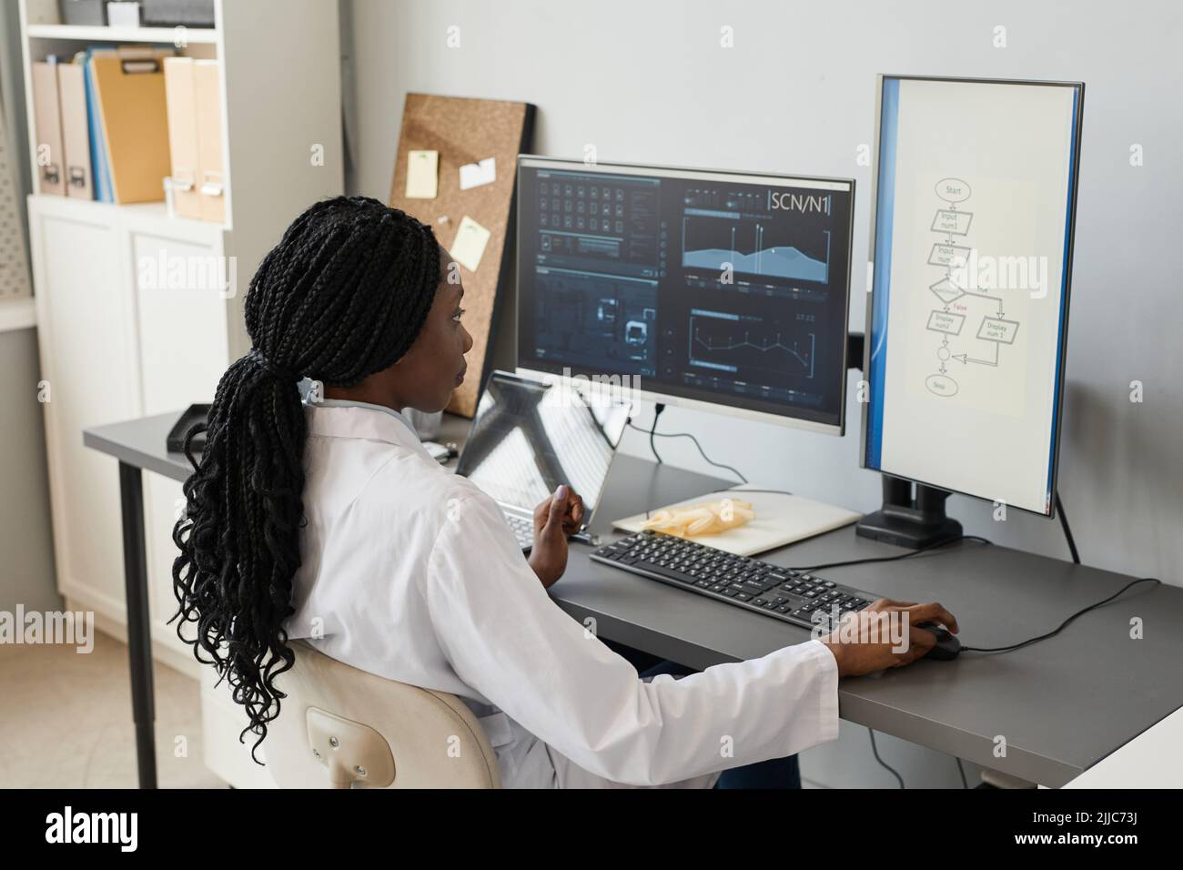 Portrait of black female engineer at workplace programming algorithms ...