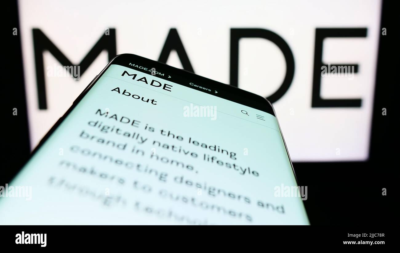 Mobile phone with webpage of British e-commerce company Made.com Group plc on screen in front of ...