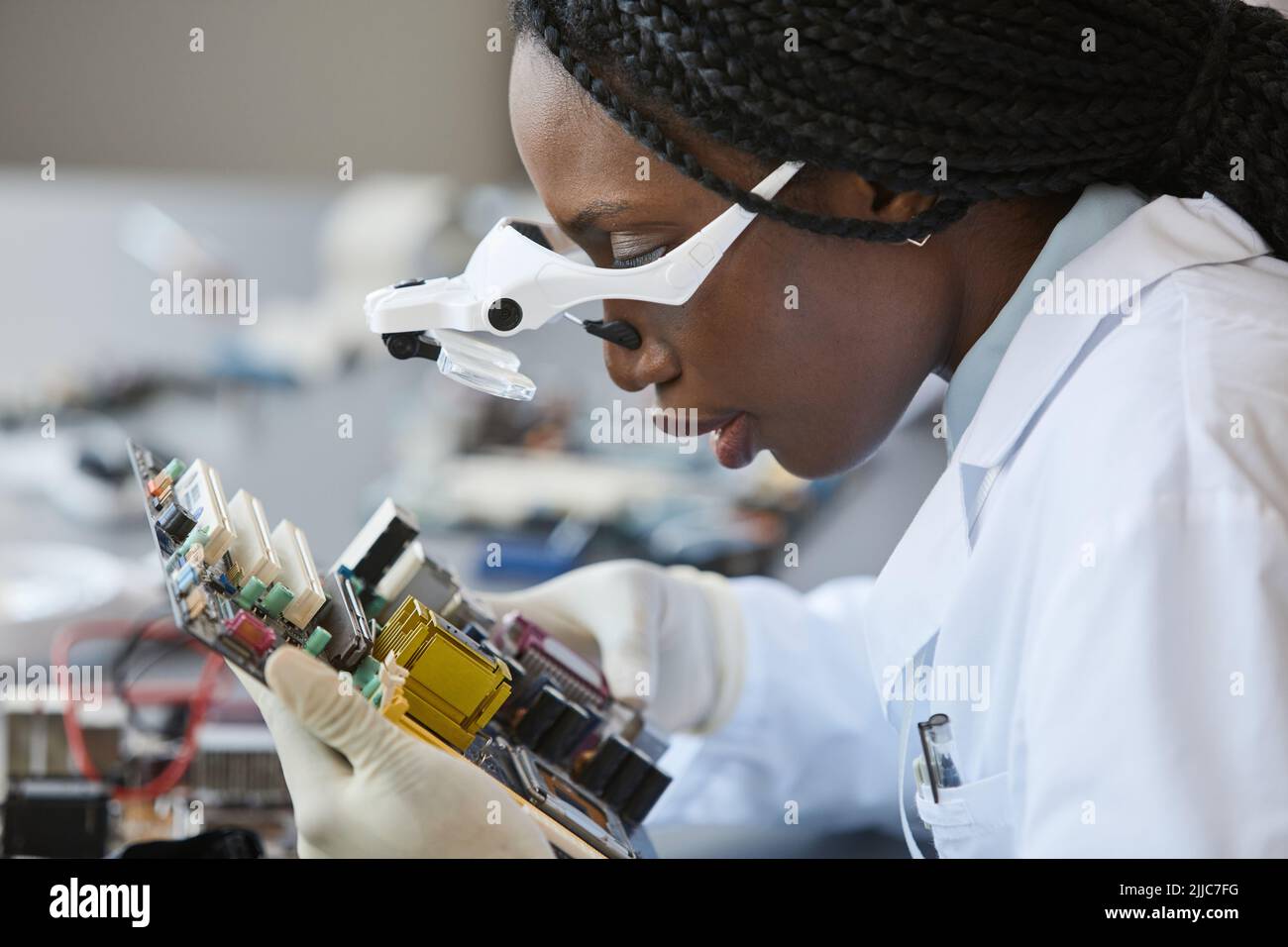 Side view portrait of black female scientist wearing magnifying glasses ...