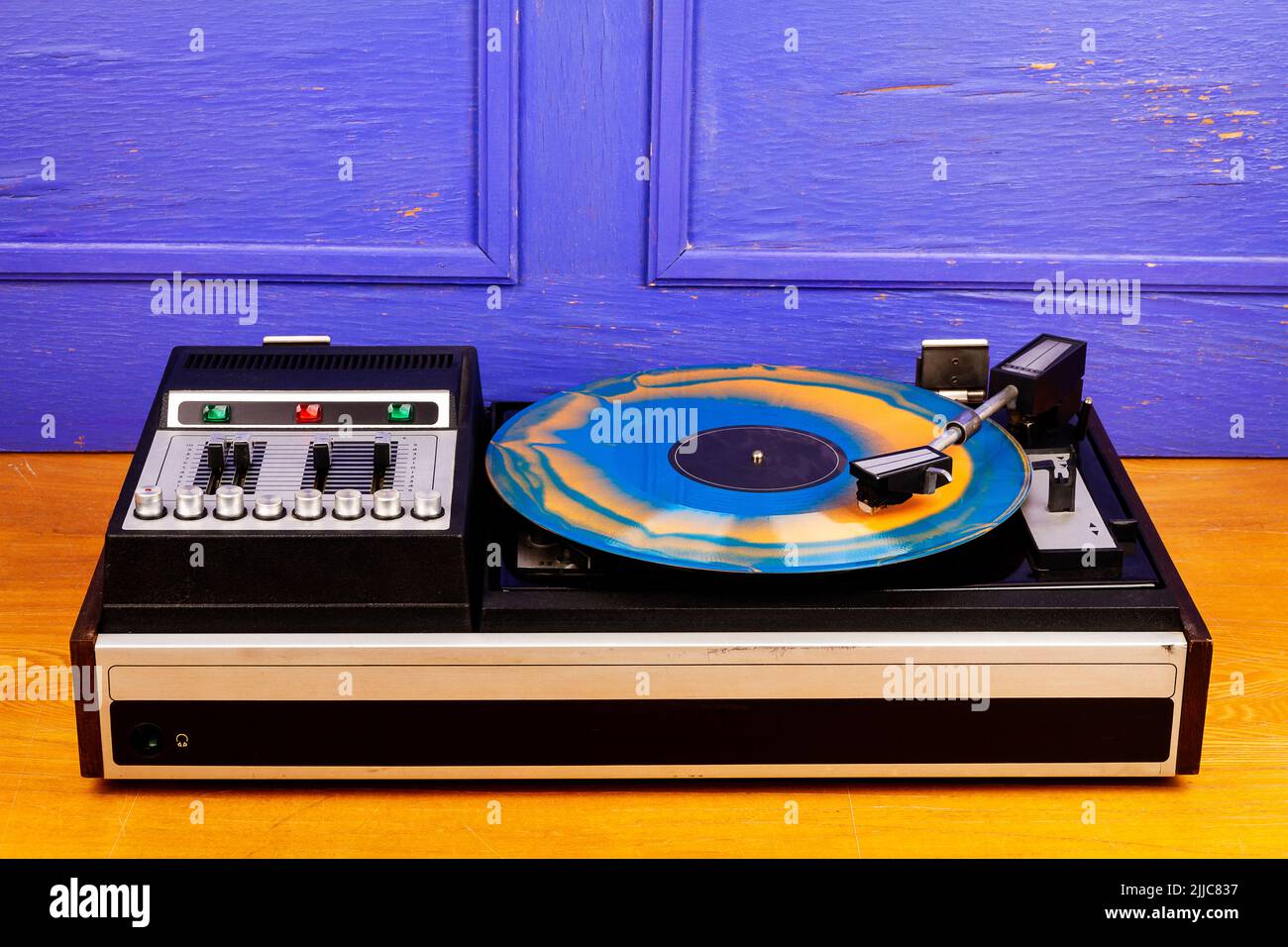 Vintage turntable vinyl record player with blue and orange vinyl on a ...