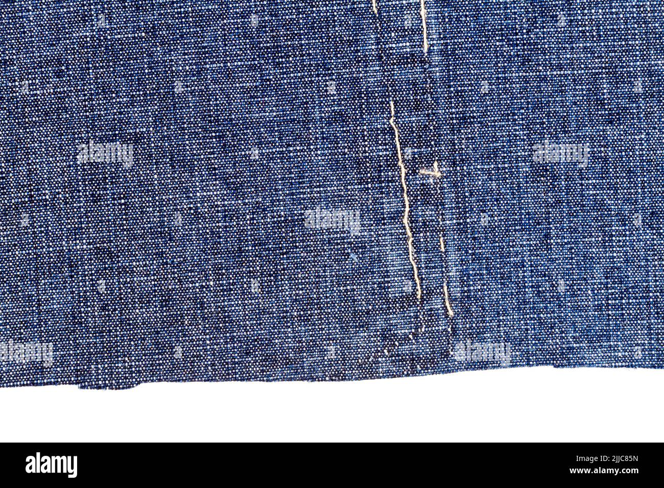 Piece of blue jeans fabric with a ripped of back pocket isolated on ...