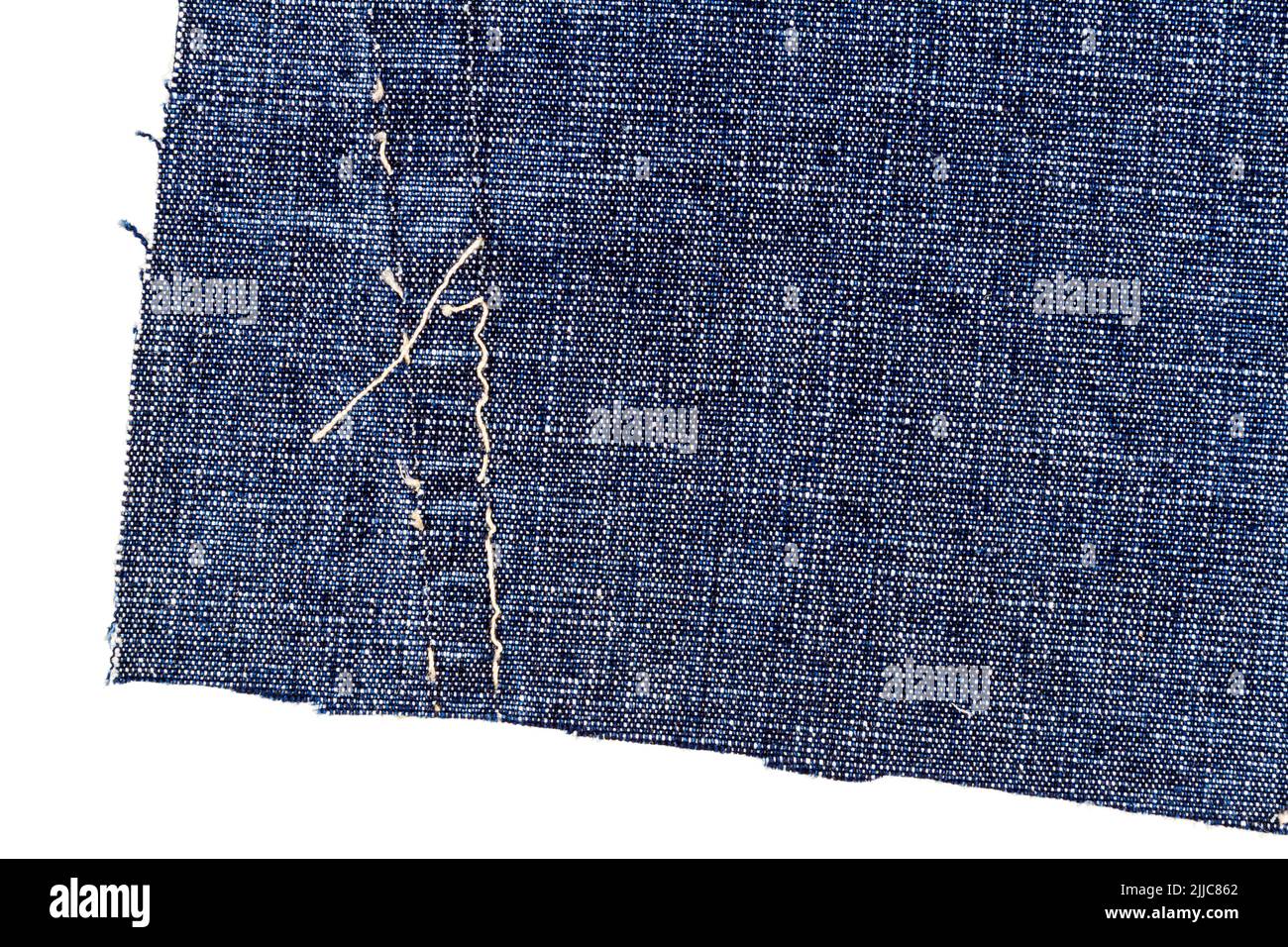 Piece of blue jeans fabric with a ripped of back pocket isolated on ...