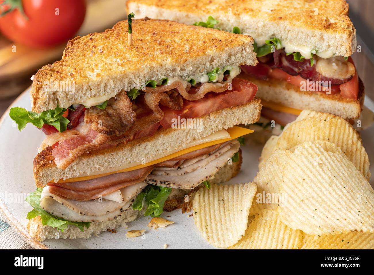 Closeup of club sandwich made with bacon, ham, turkey, cheese, lettuce ...