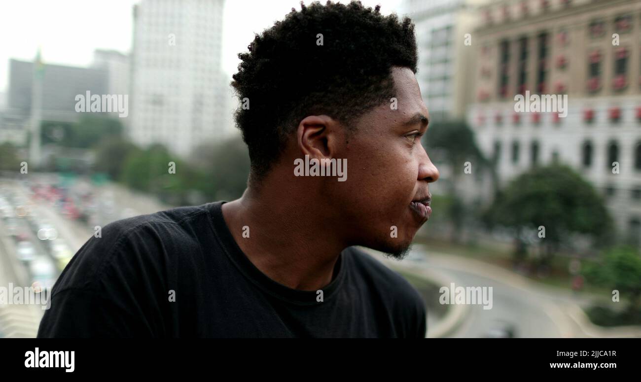 Frustrated young black African man standing outside in city Stock Photo ...