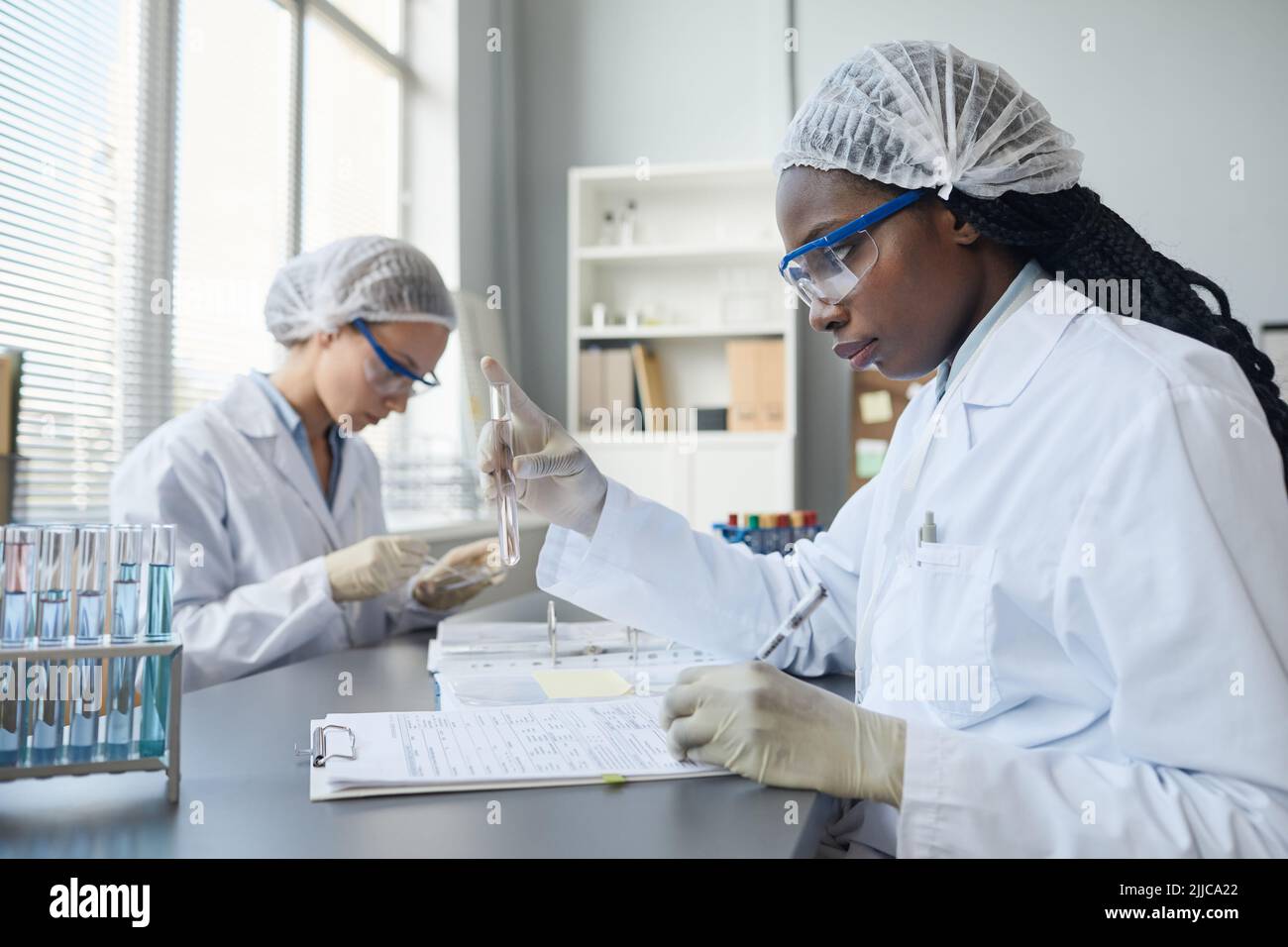 Side view portrait of African American lab technician doing experiments ...
