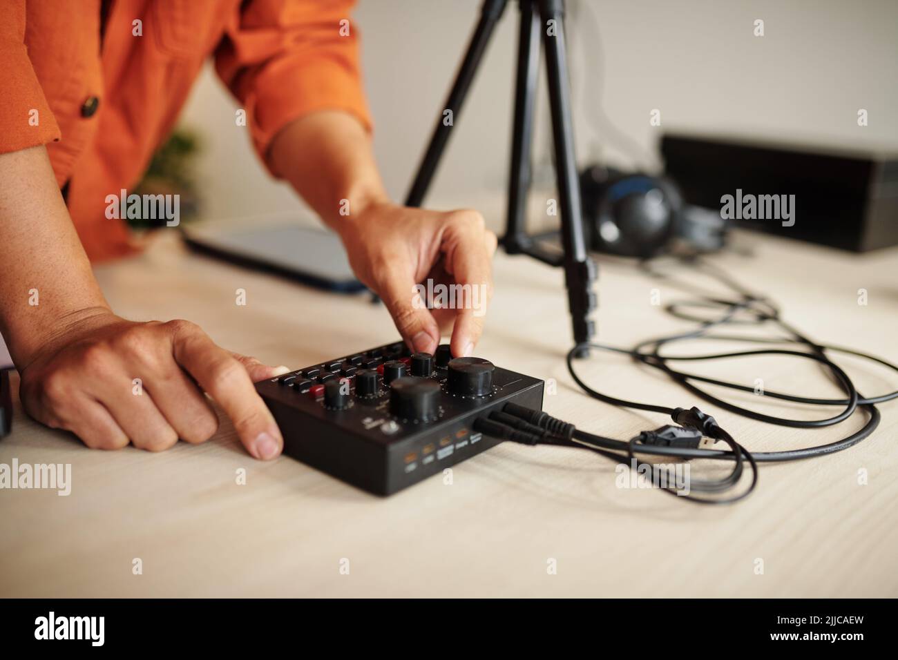 Closeup image of blogger using volume controller to adjust sound of ...