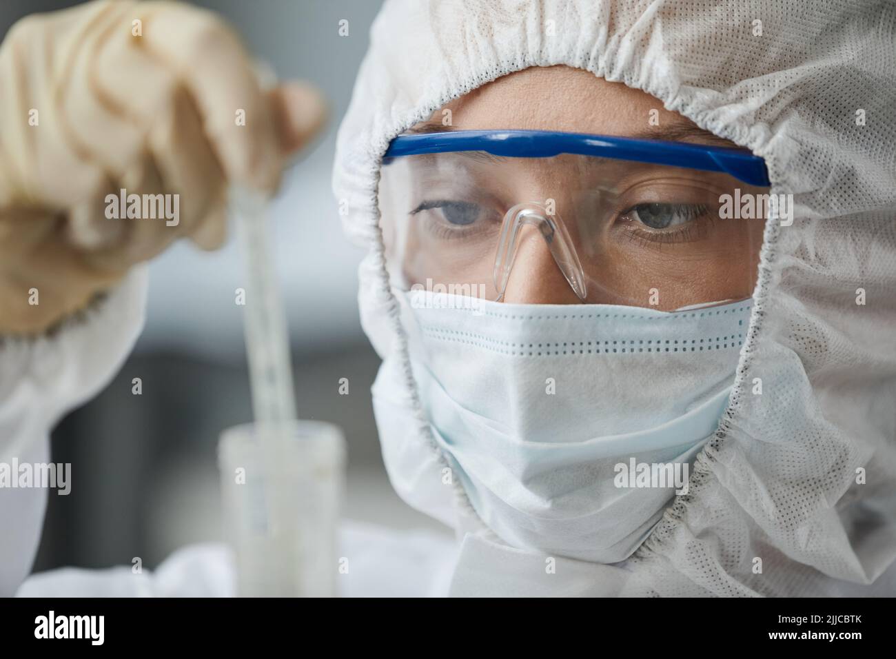 Side view portrait of two female scientists wearing full protective ...