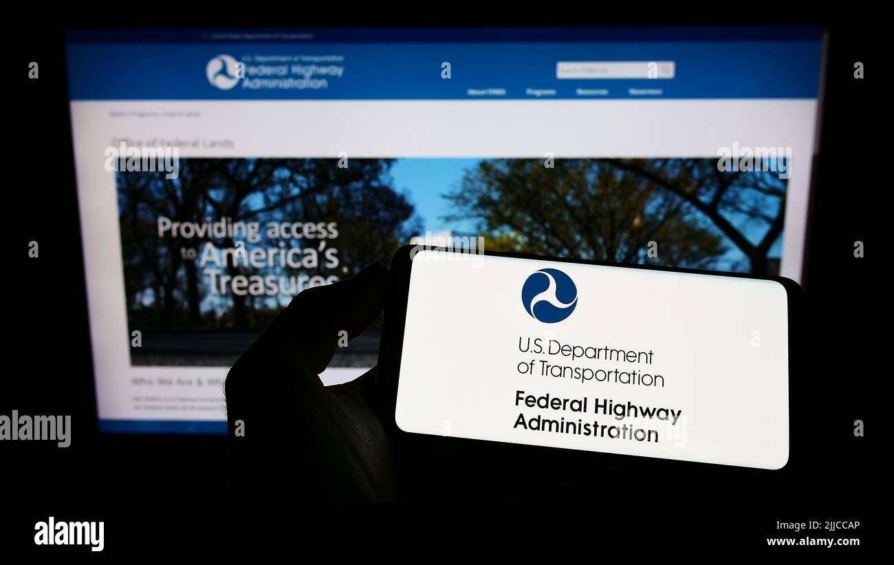 Person holding mobile phone with logo of US Federal Highway ...