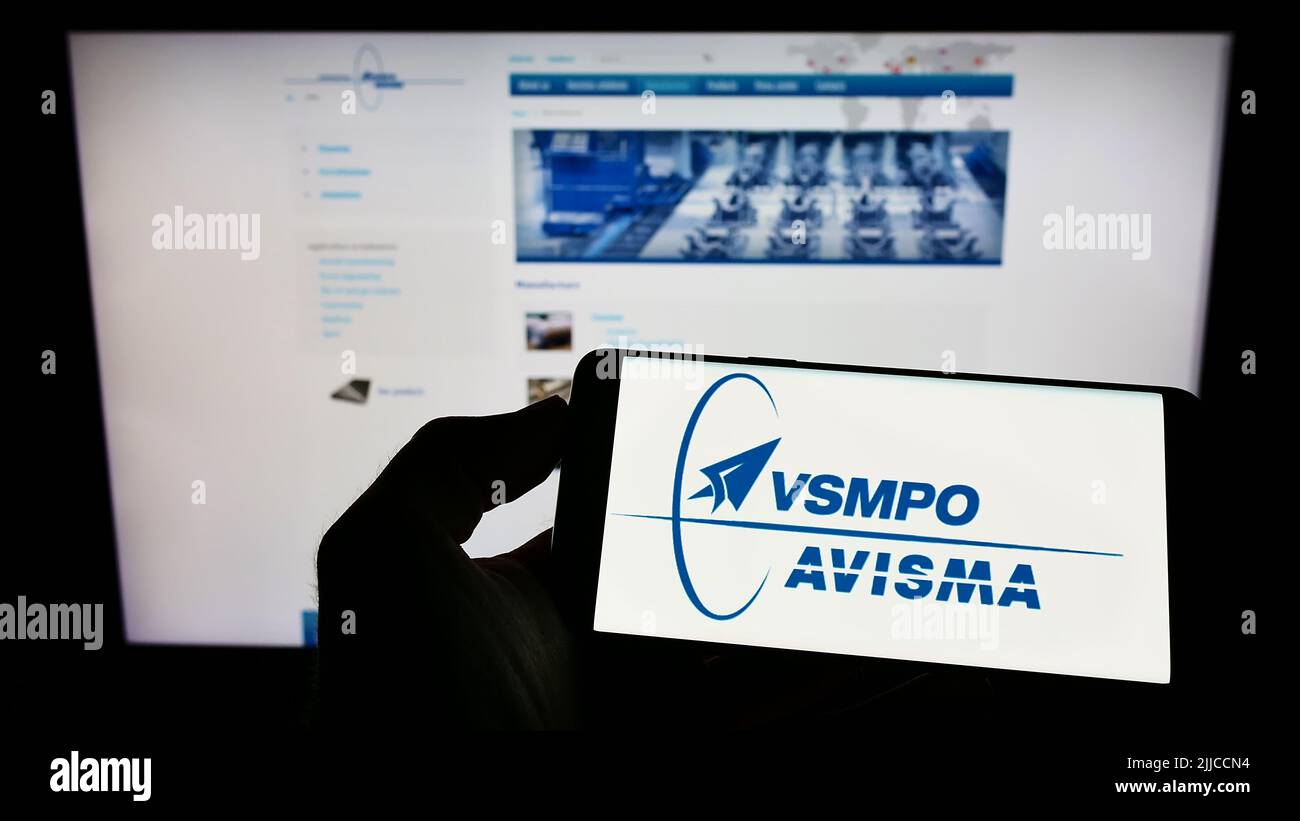 Person holding cellphone with logo of Russian titanium company VSMPO ...
