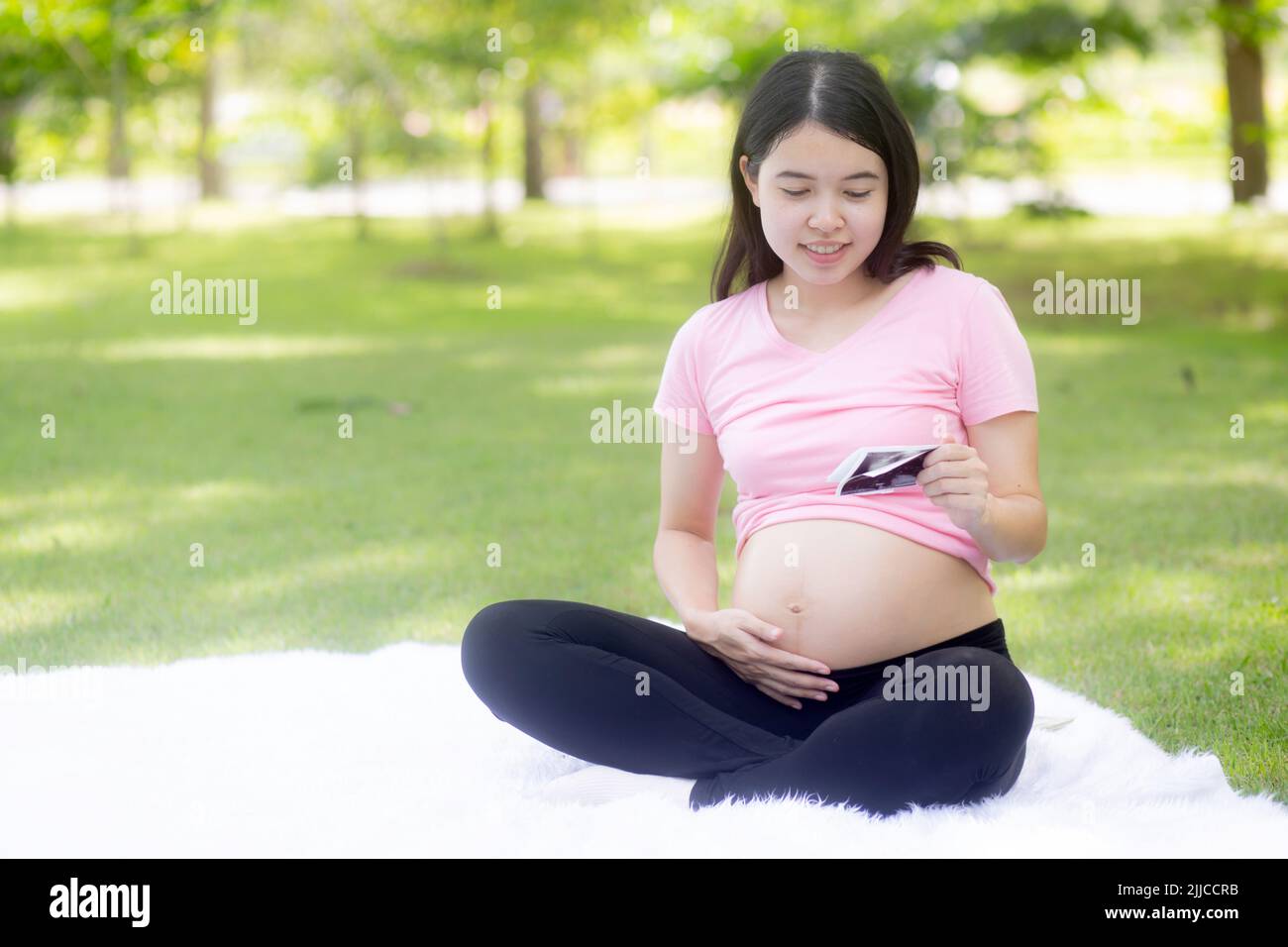 Happiness young asian woman pregnant sitting touch belly and looking ...