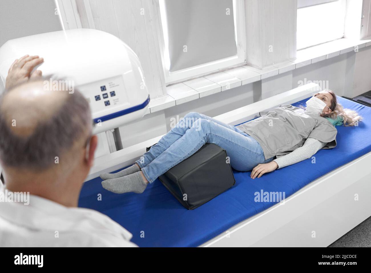 Aged doctor using a x-ray machine with a patient Stock Photo - Alamy