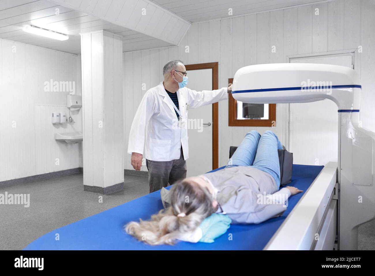 Doctor introducing a patient to the x-ray machine Stock Photo - Alamy
