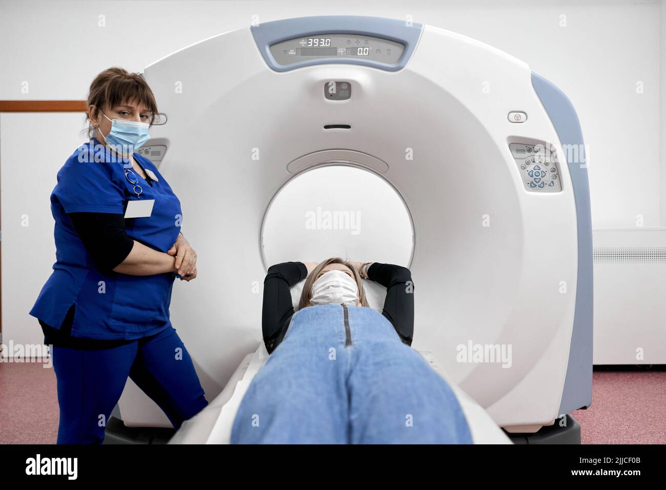 Patient into a tomography machine next to a doctor Stock Photo - Alamy