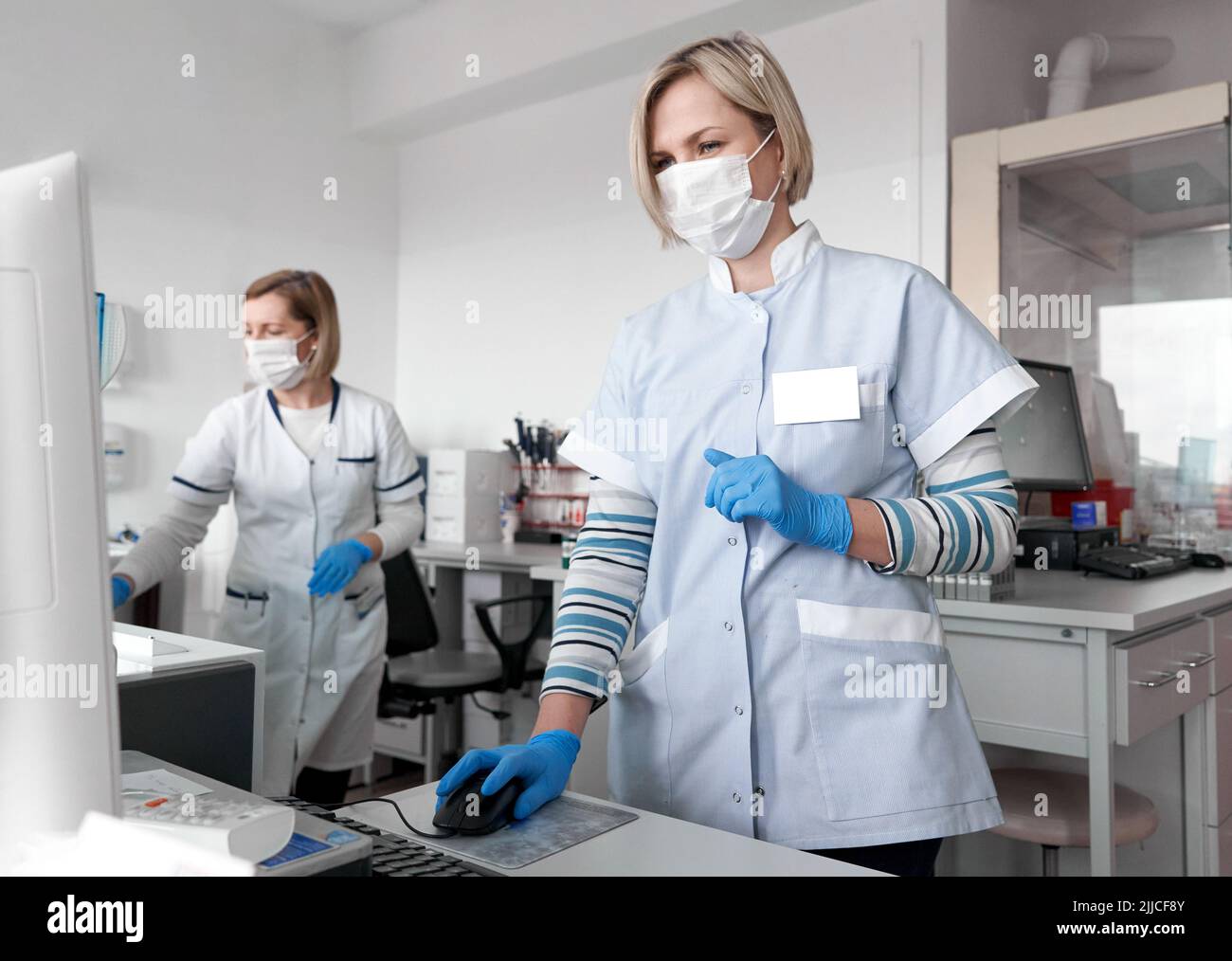 Two workers in a office using a computer and a centrifuge machine Stock ...