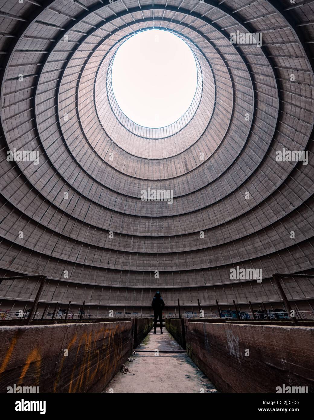 A back view of a man standing inside Power Plant IM-site abandonne in ...