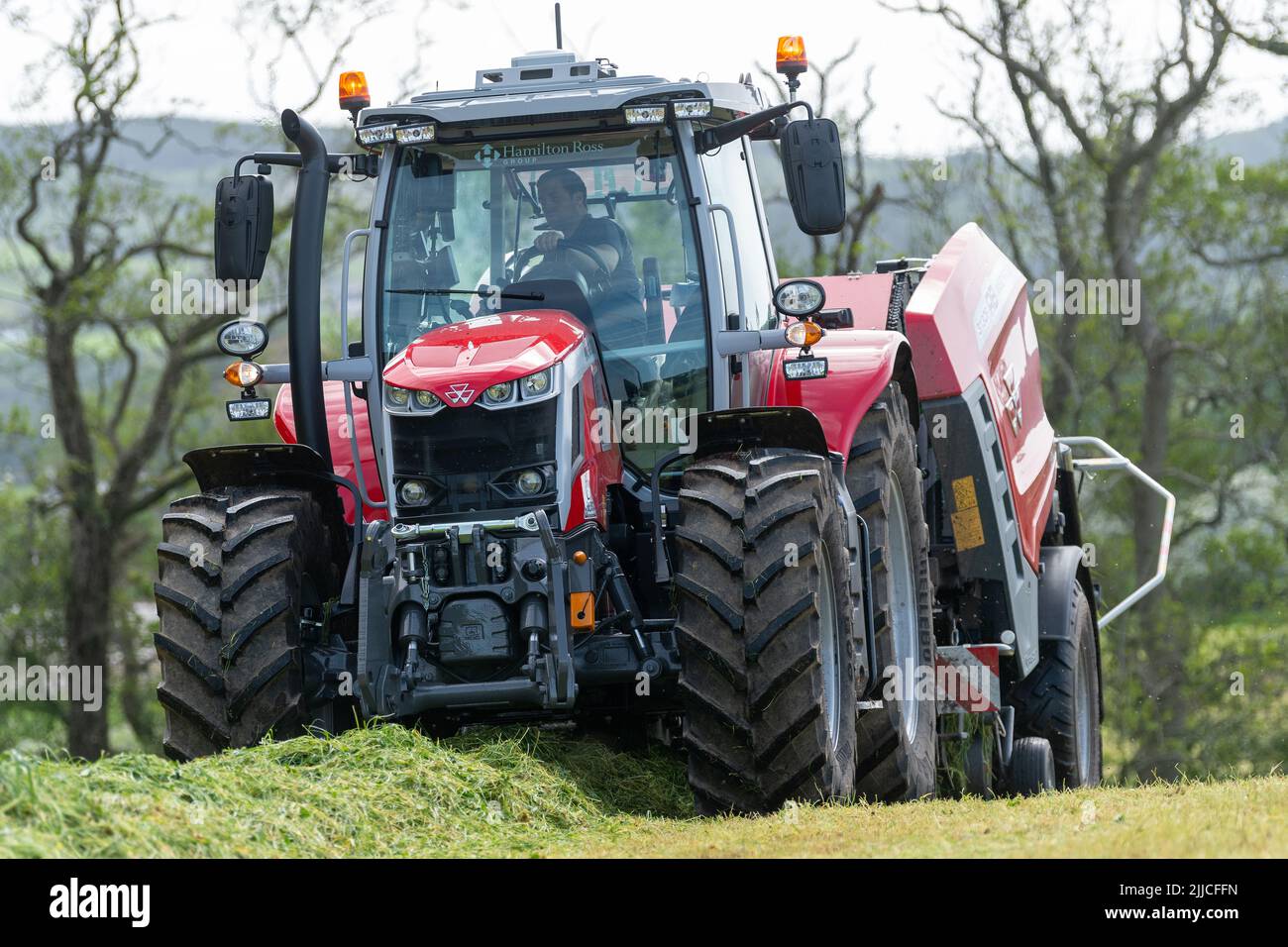 Red tractor cutting grass hi-res stock photography and images - Alamy