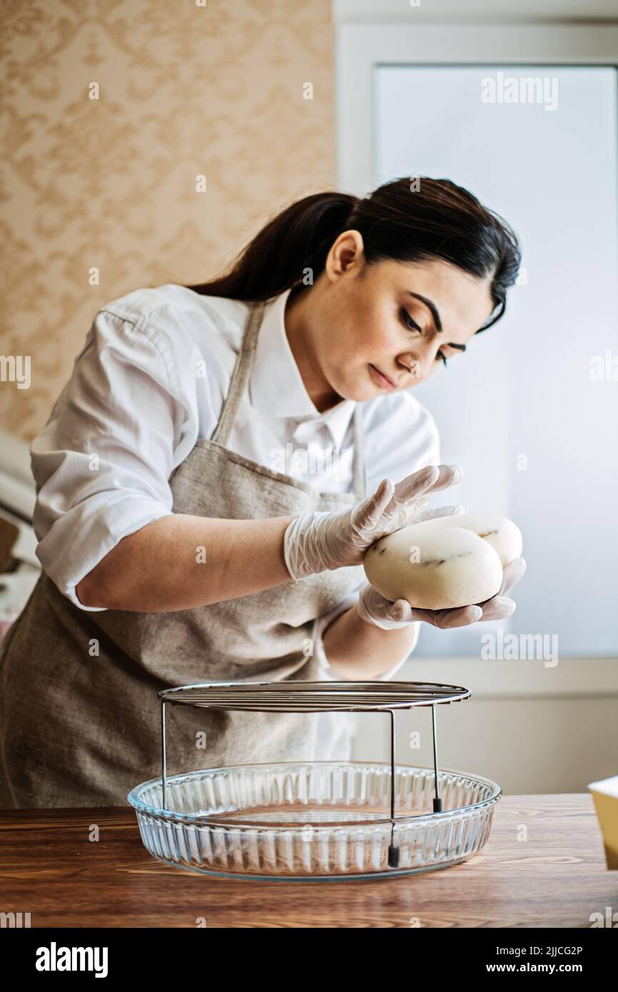 Central Asian Arabic woman pastry chef making Mirror Glaze Mousse cake ...