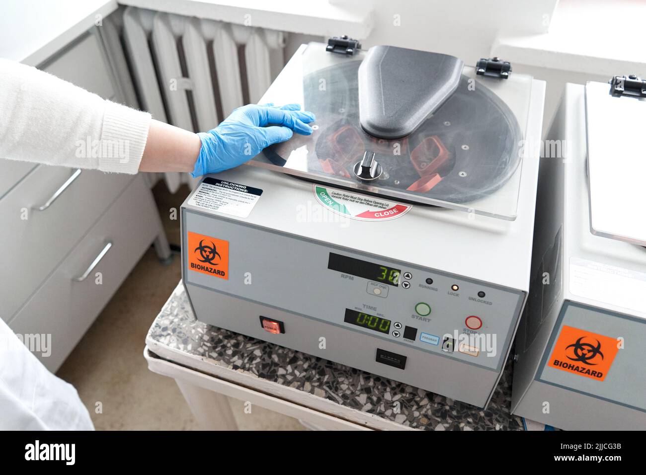 Close up view of a doctor using the reaction vessel of a centrifuge in ...