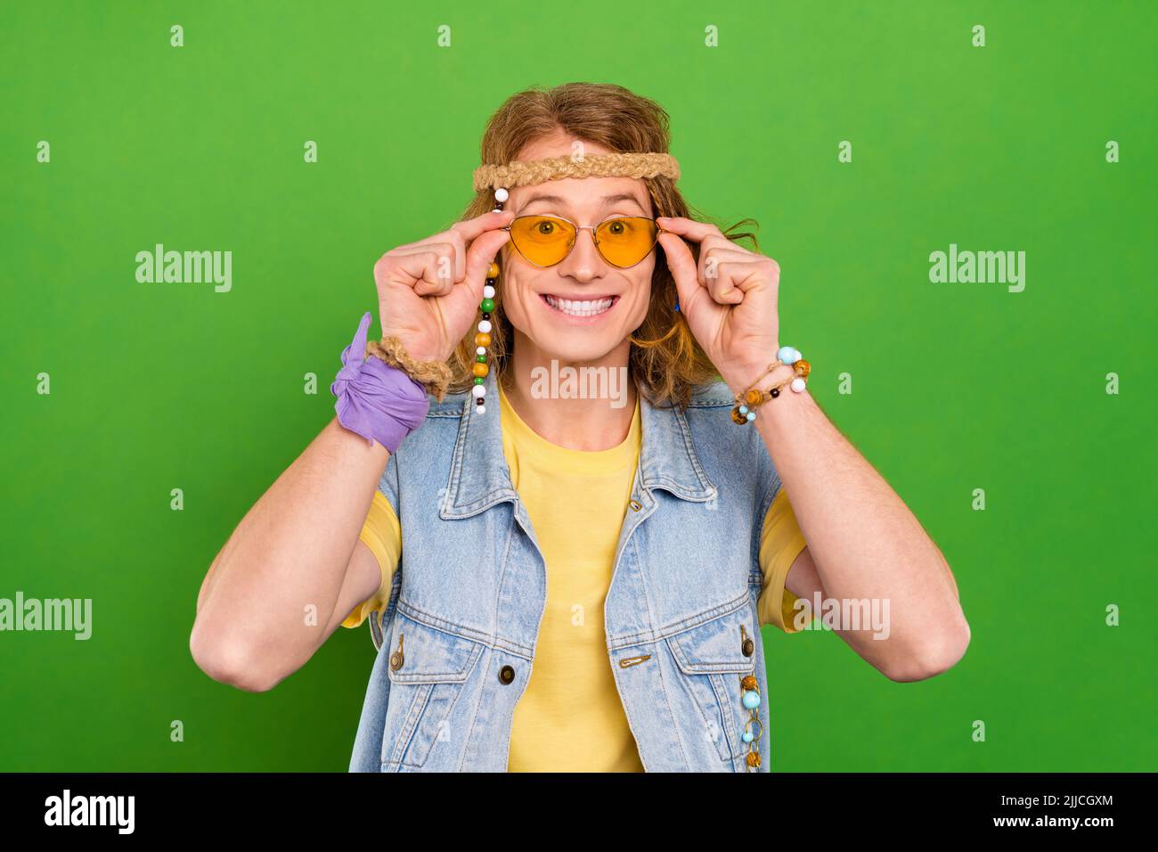 Portrait of attractive cheerful hippie guy touching specs good mood ...