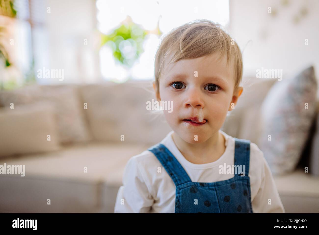 A portrait of sad little girl with snot running through her nose ...