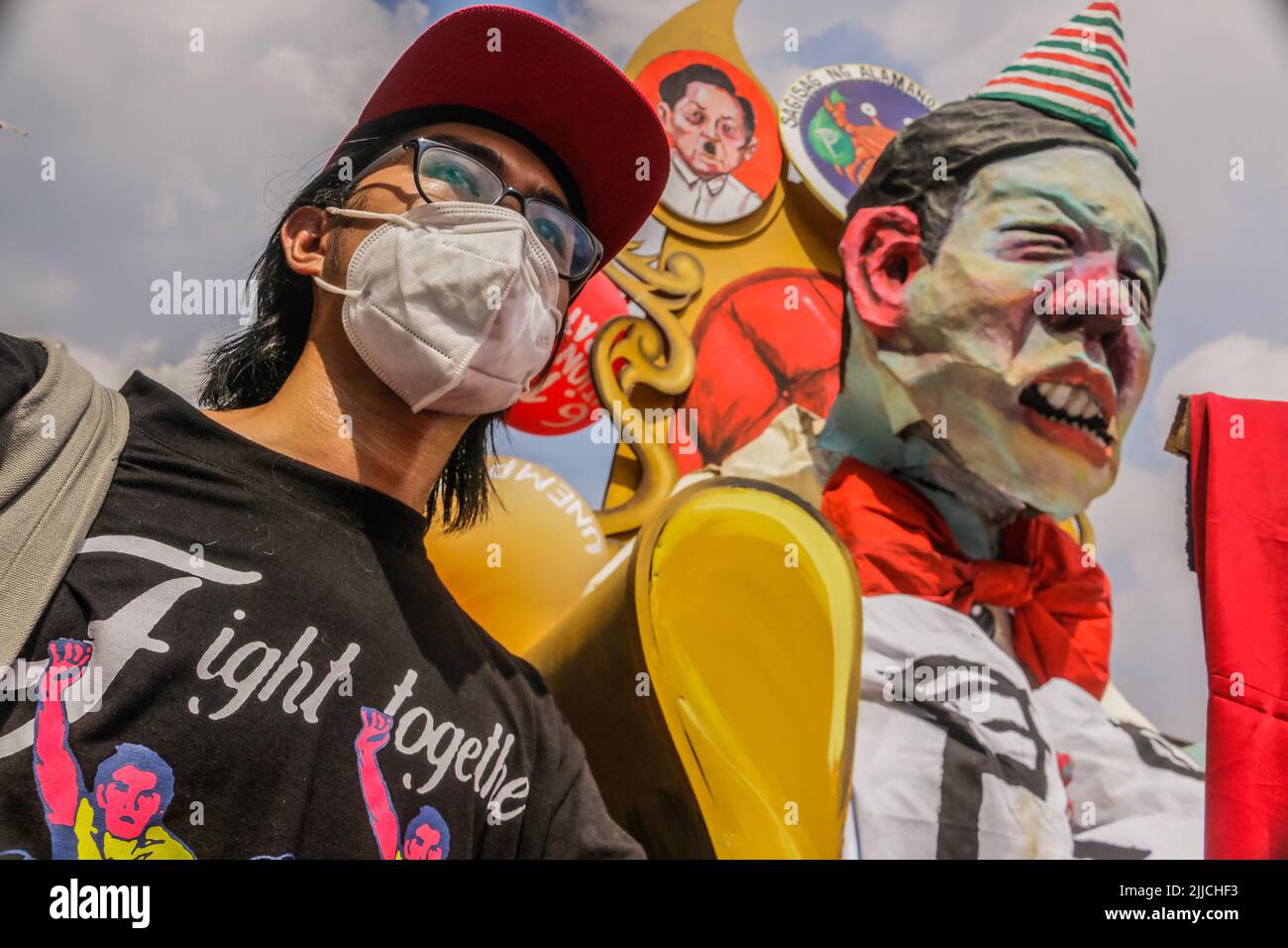 A protester stand beside the effigy of President Ferdinand Marcos Jr ...