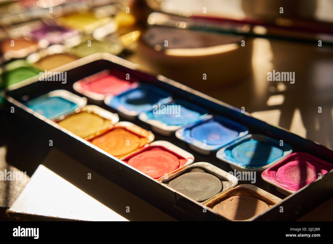 watercolor paints are laid out on the table in the sunlight Stock Photo ...