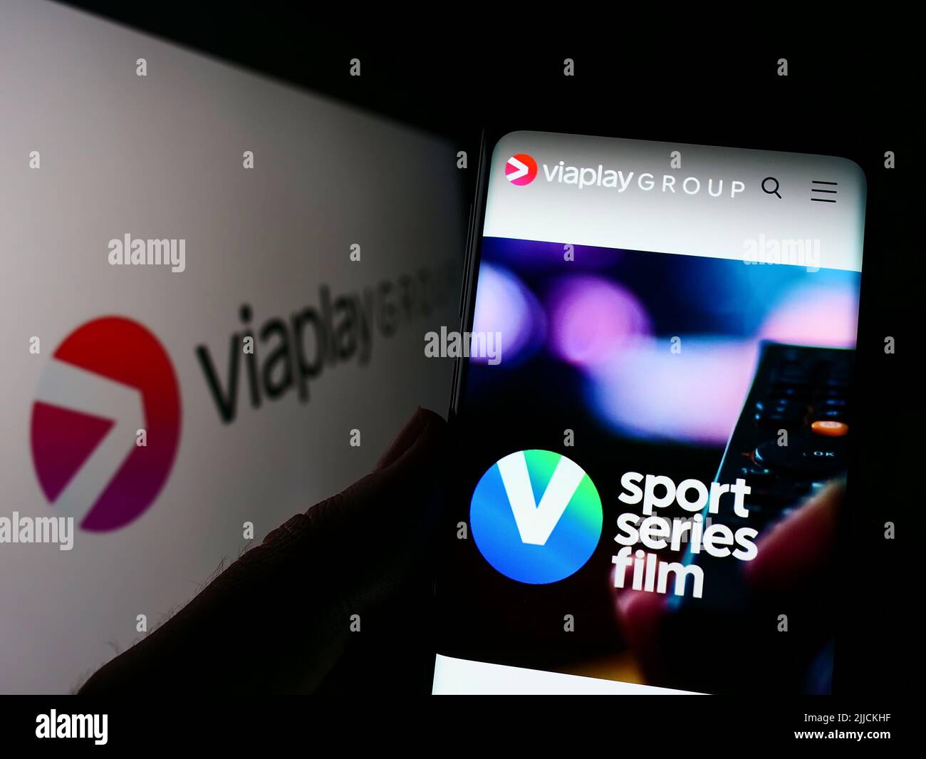 Person holding cellphone with webpage of Swedish media company Viaplay Group AB on screen in ...