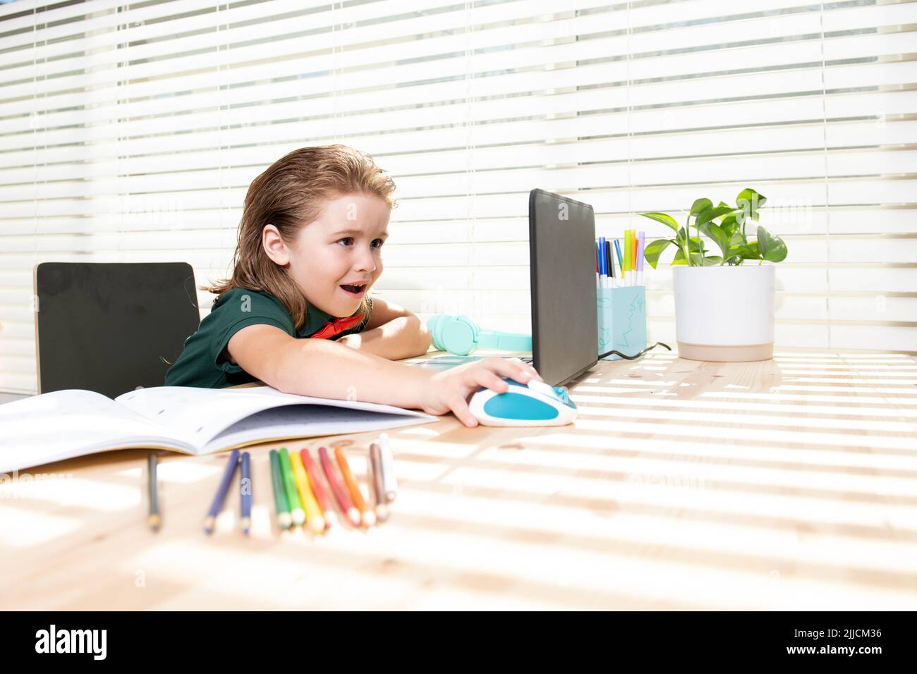 Smart school boy at home writing homework. Little student with notebook ...