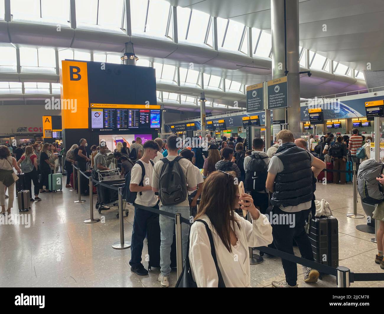 Passengers queue to check-in at terminal 2 at Heathrow Airport, London ...