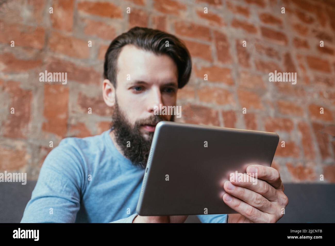focused man reading tablet knowledge access info Stock Photo - Alamy