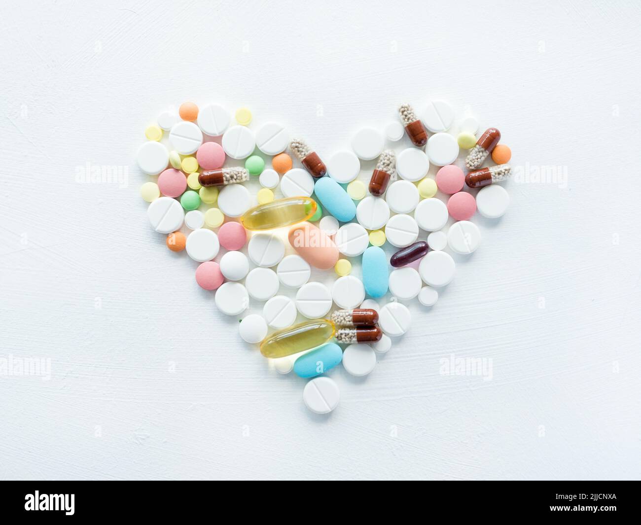 pill mix heart shape medication illness cure white Stock Photo - Alamy