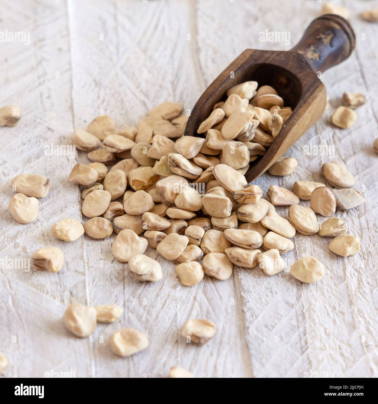Scoop of raw dry Grass pea close up on wood. Healthy, protein source ...