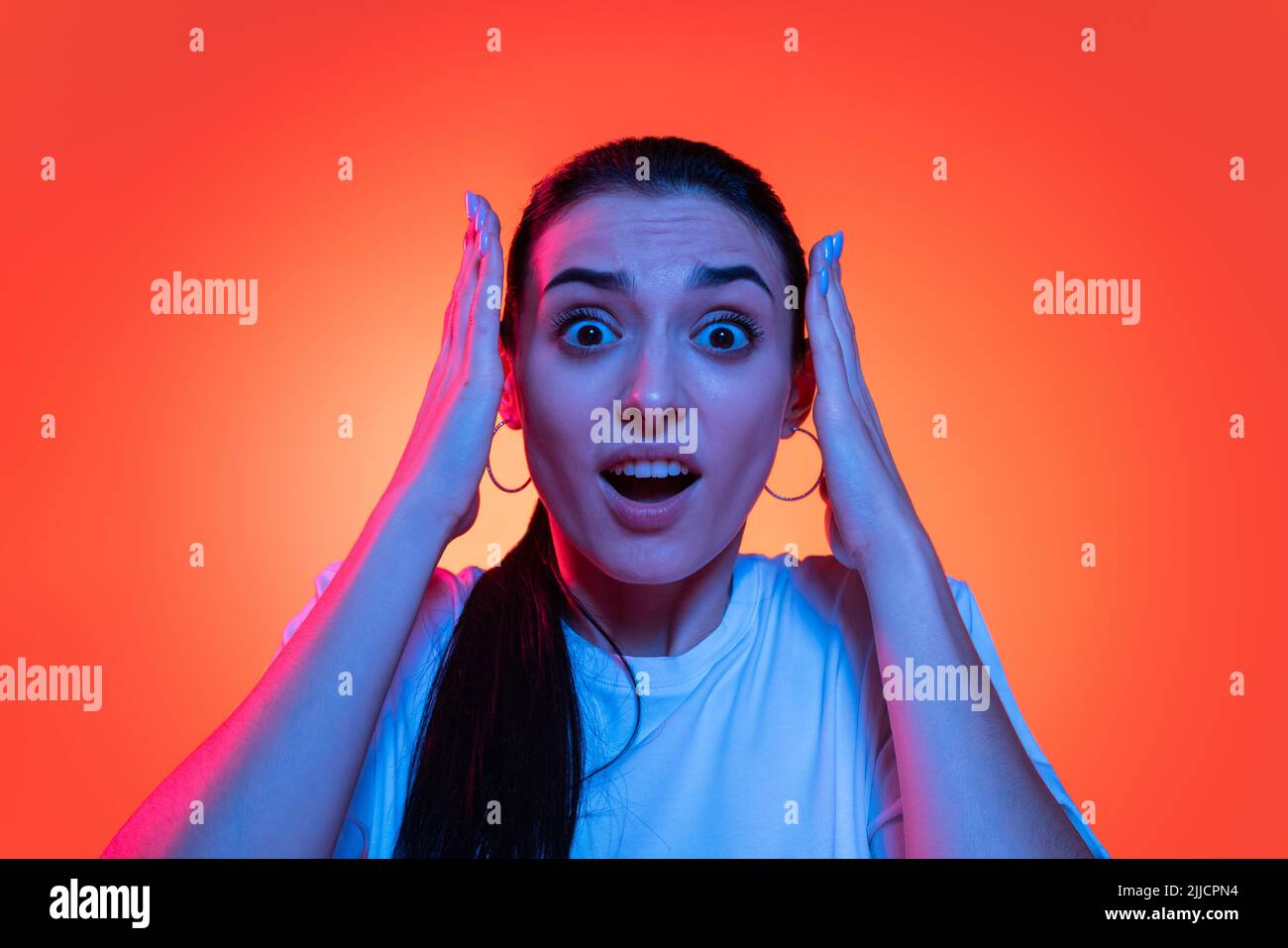 Young emotional stressed girl, student in white t-shirt looking at ...