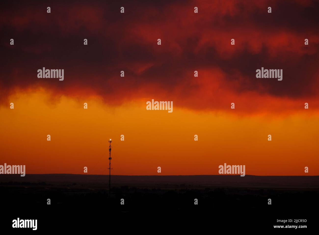 Silhouette of cell tower at sunset on skyline for digital communication ...