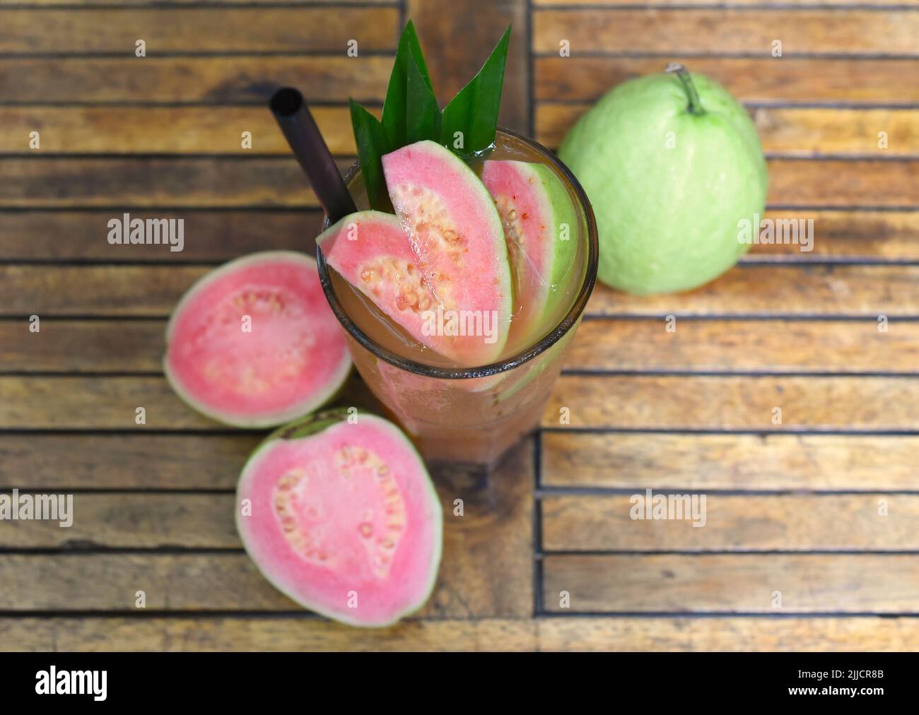 Pink guava ice tea on wooden table background with sliced guava Stock Photo - Alamy
