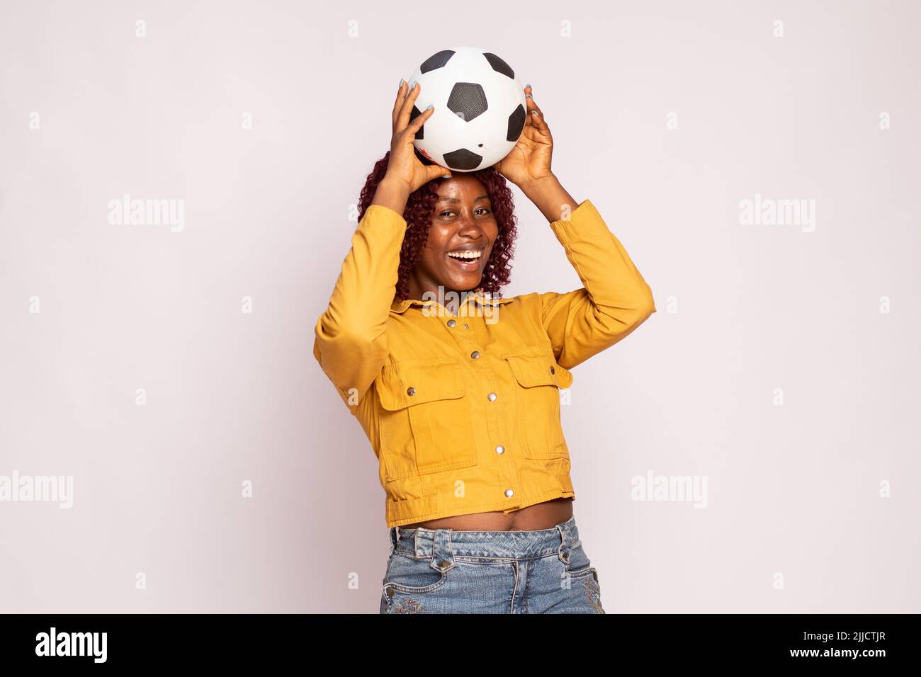 excited black lady playing with a football Stock Photo - Alamy