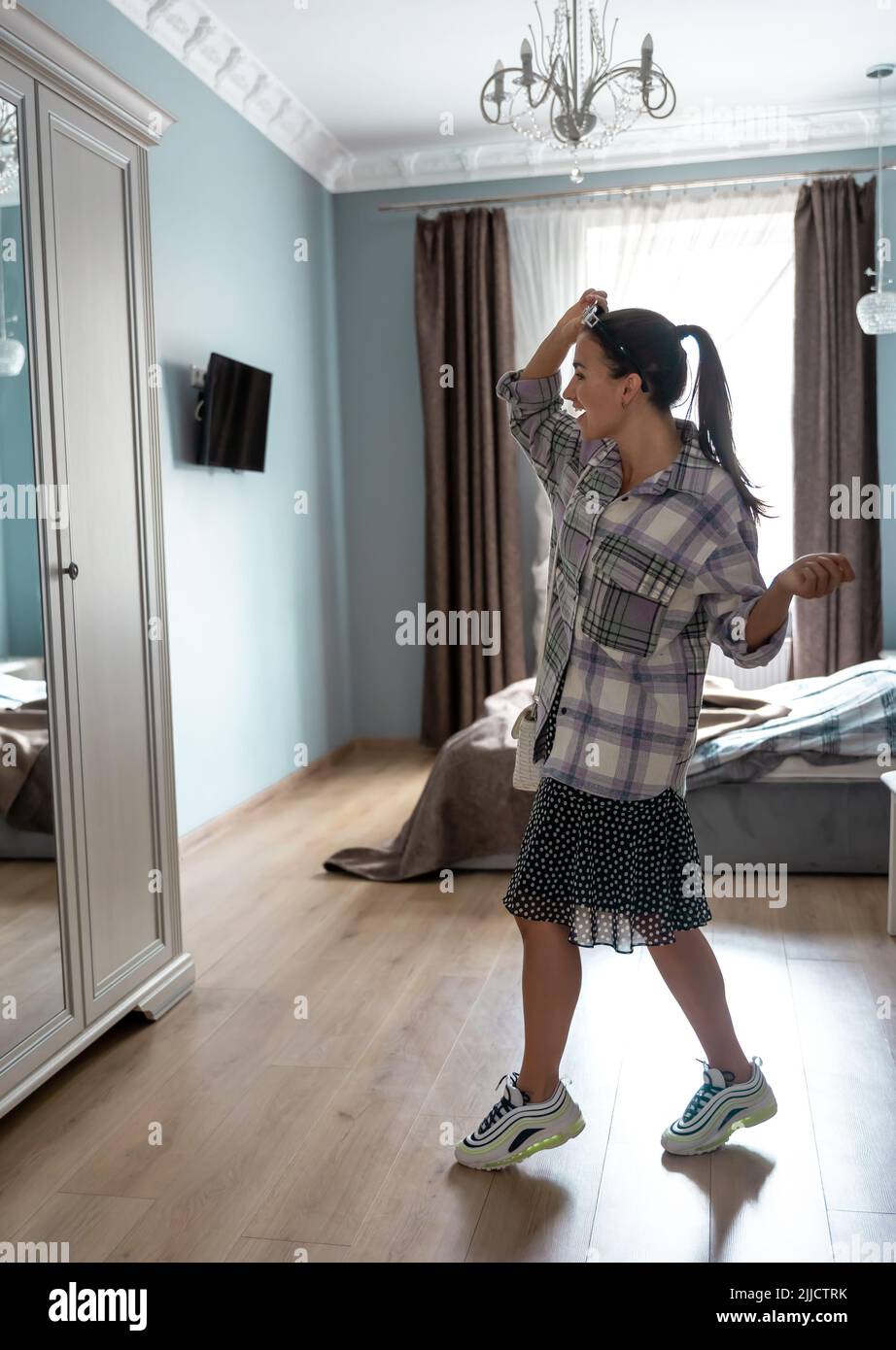 Stylish young woman in front of a mirror in the room, gathering Stock ...