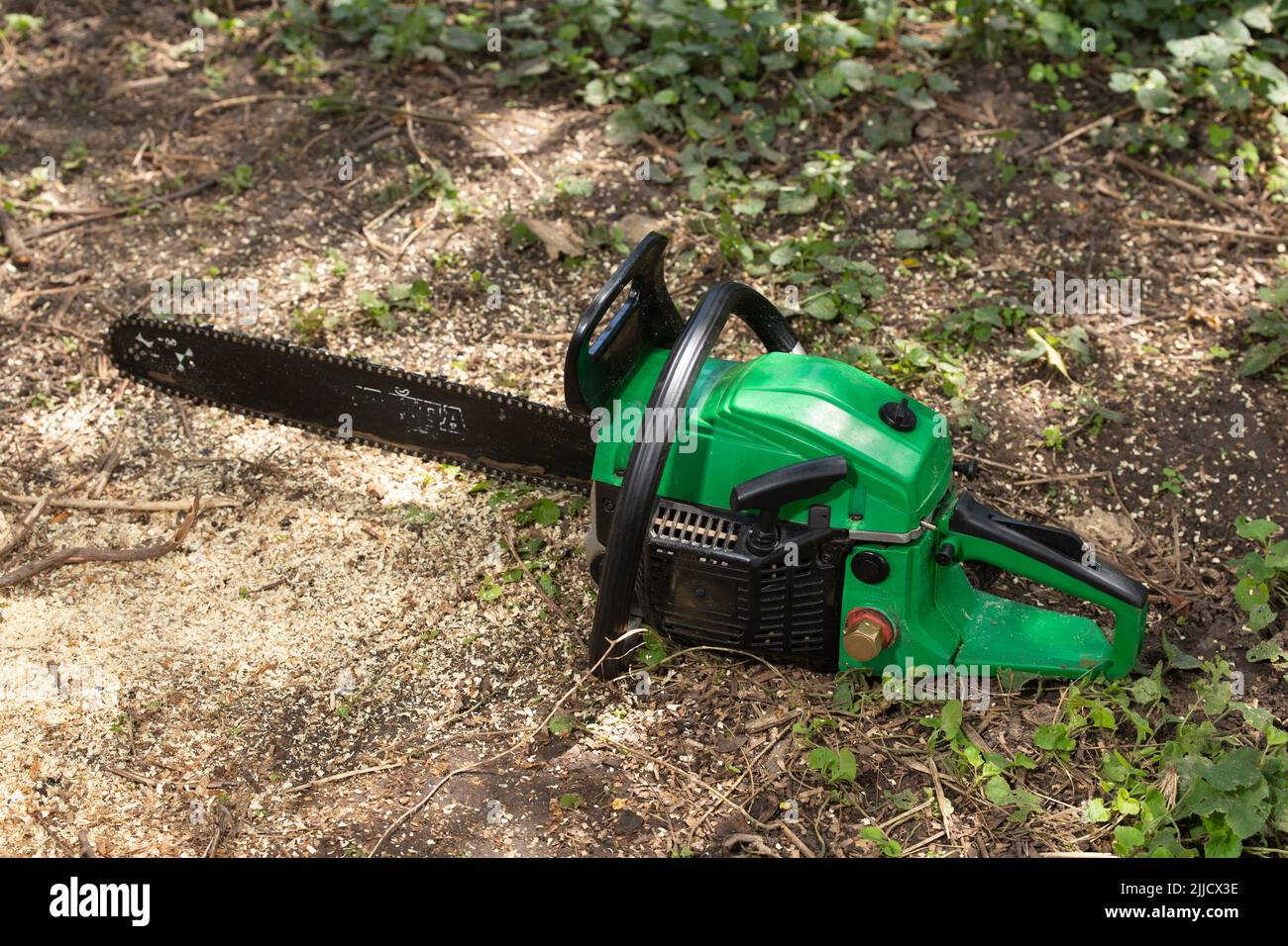 Hand gasoline saw lies on the ground Stock Photo - Alamy