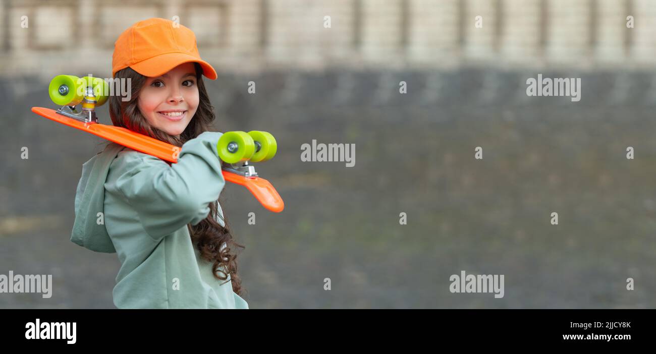 smiling teen kid skater with skateboard outdoor. girl with penny board ...