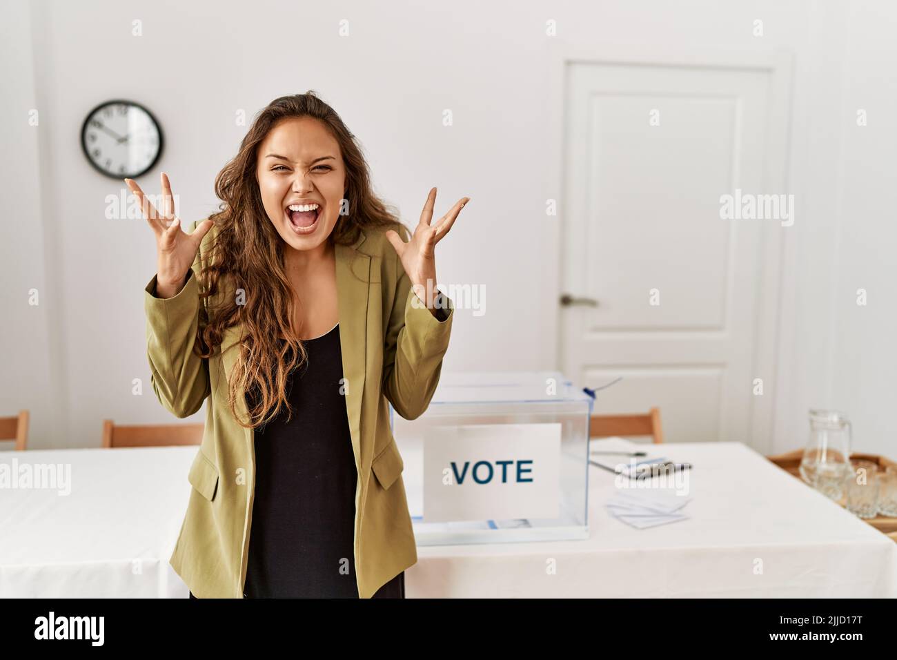 Beautiful hispanic woman standing at political campaign room ...