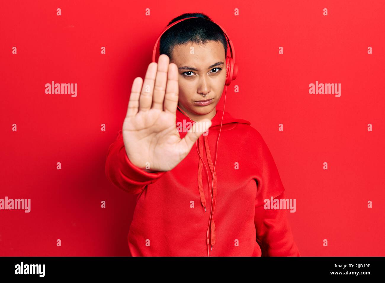 Beautiful hispanic woman with short hair listening to music using ...